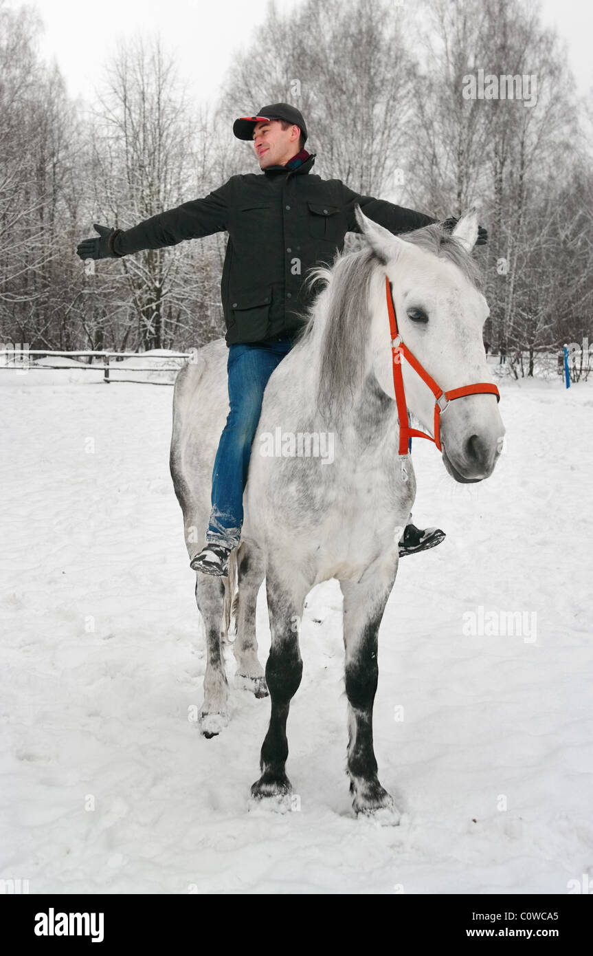 The happy young guy sits on a stallion Stock Photo - Alamy