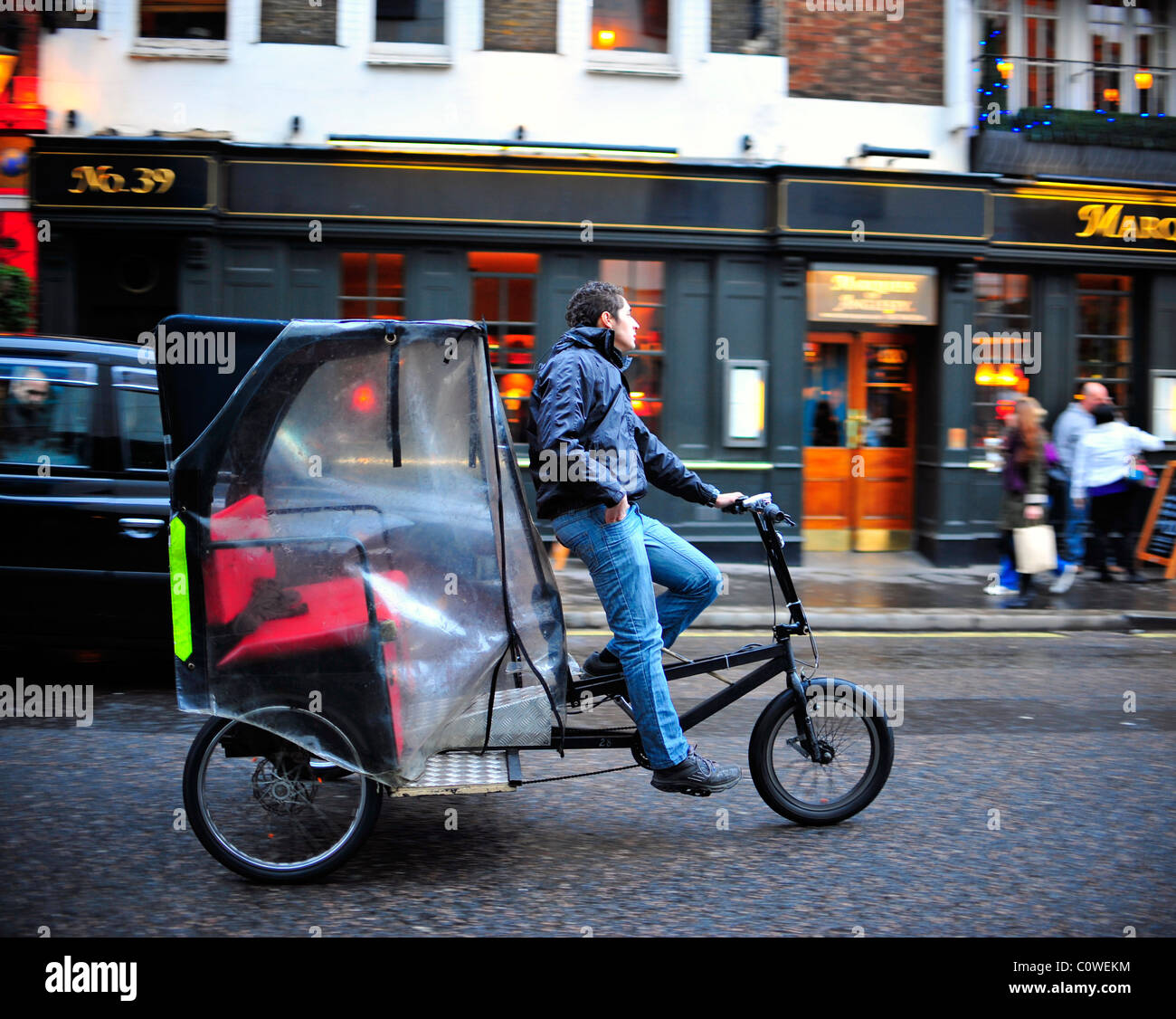 Rickshaw taxi rider in motion on a street in London Stock Photo - Alamy
