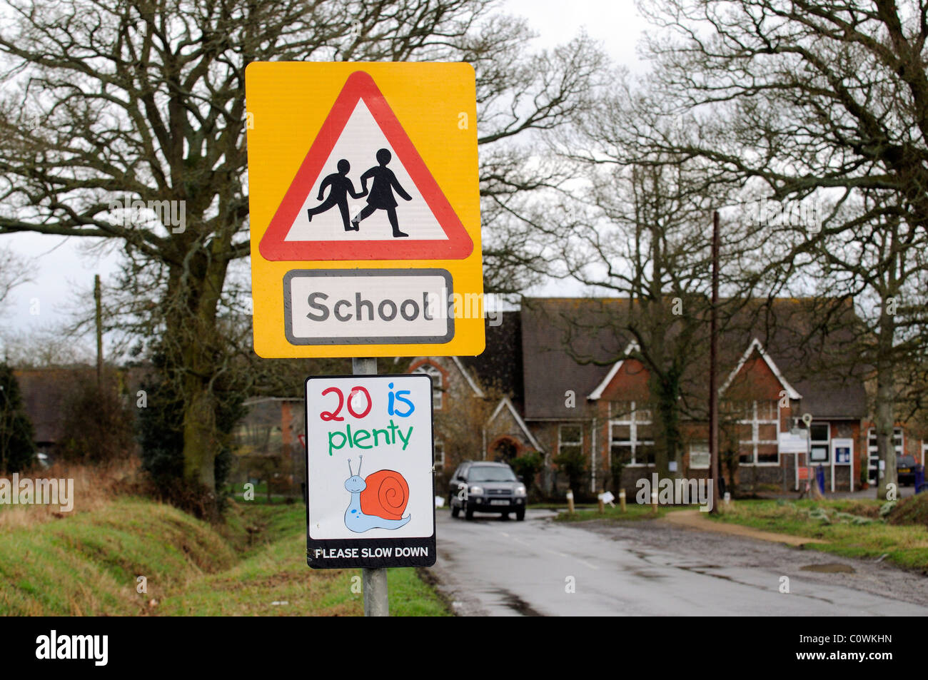 Roadside school sign and 20 mph please slow down signage on an approach ...