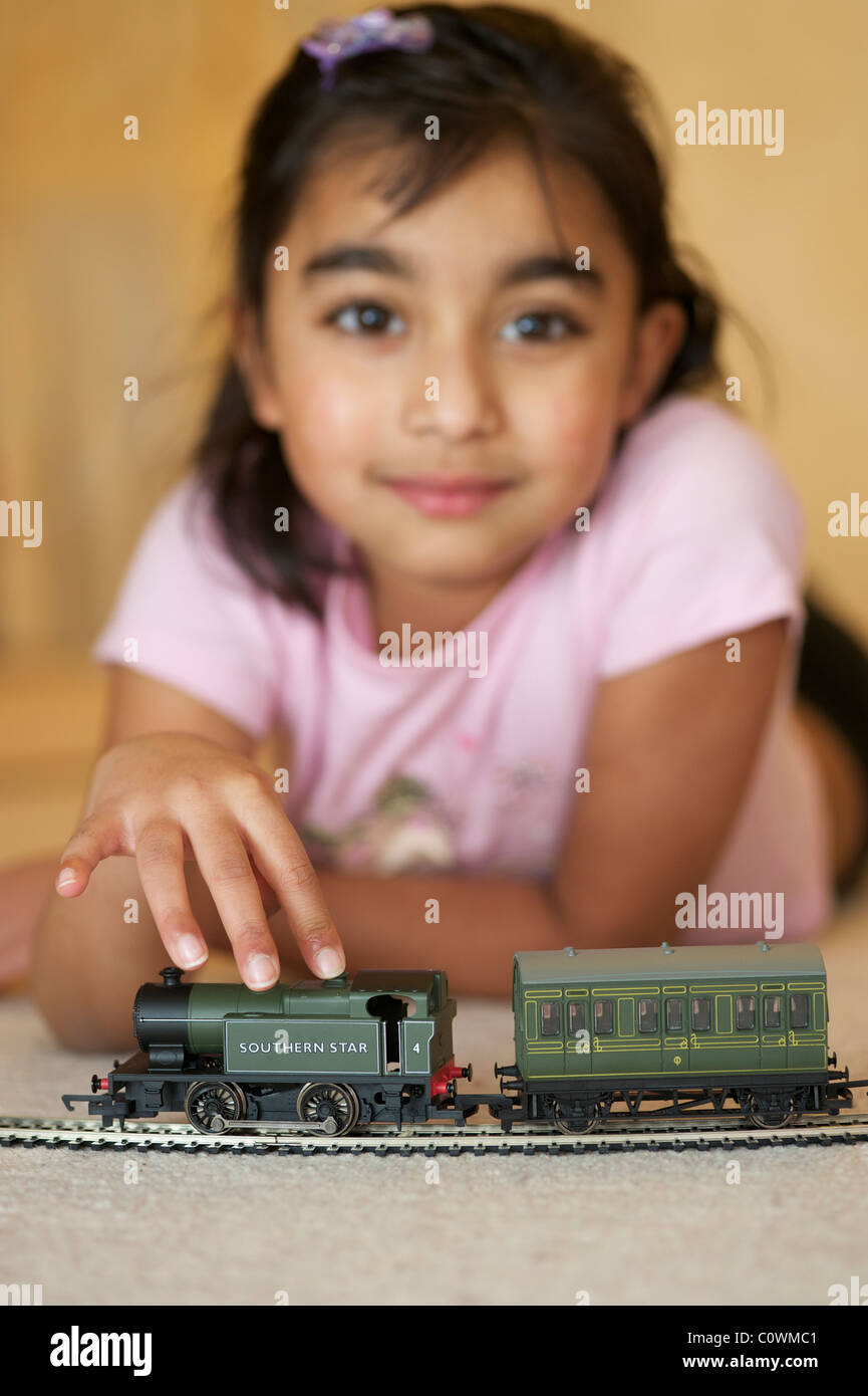 A young girl playing with her toy train set Stock Photo - Alamy