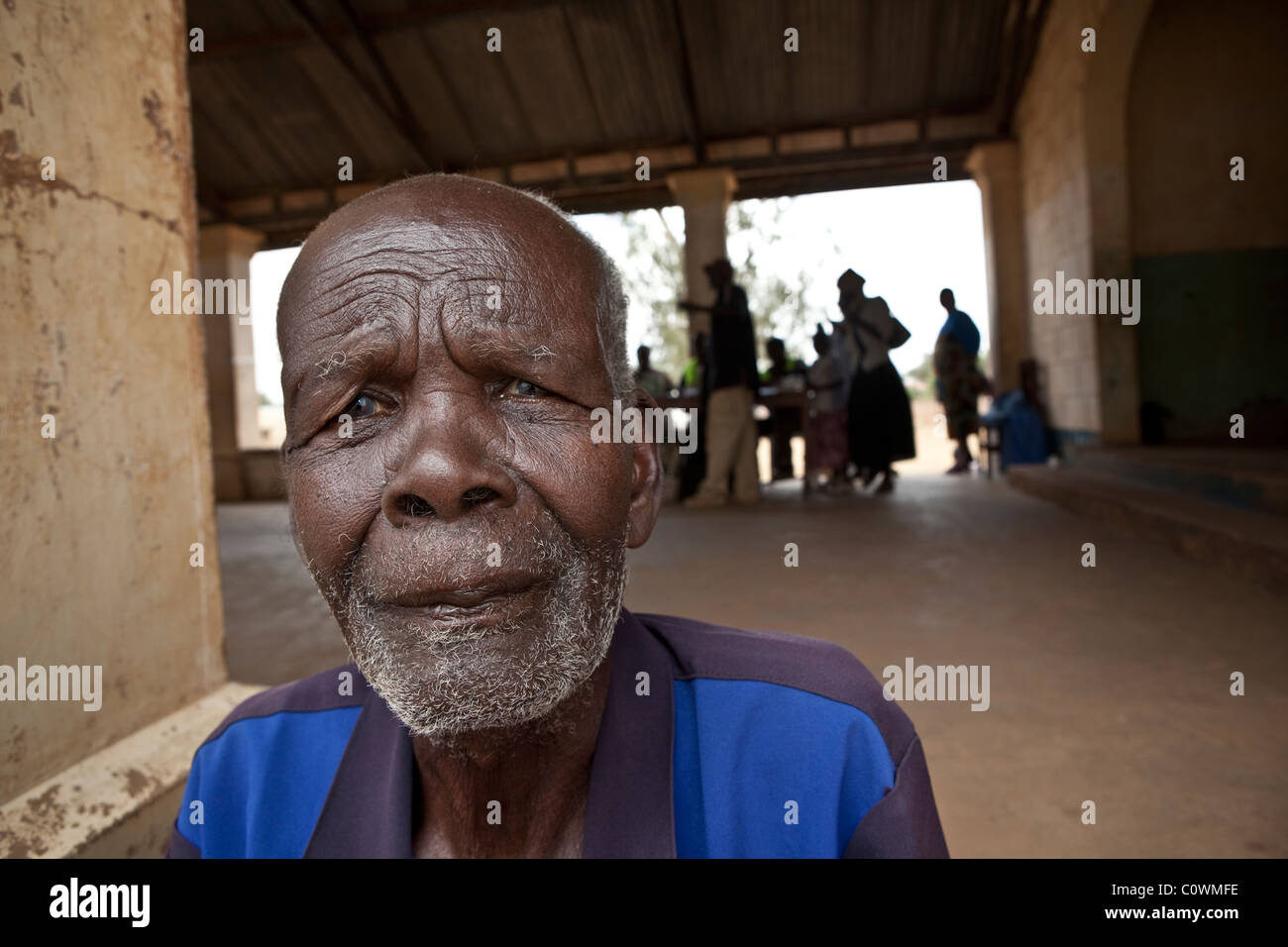 An elderly sits outside a health centre in Kumi, Uganda, East Africa ...
