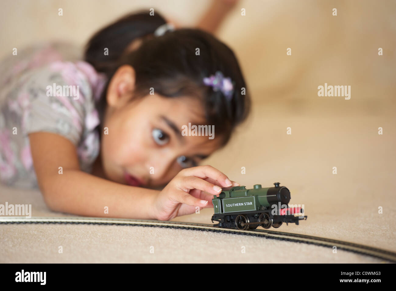 A young girl playing with her toy train set Stock Photo - Alamy