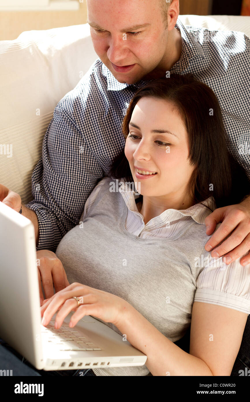 Couple browsing web using laptop Stock Photo - Alamy
