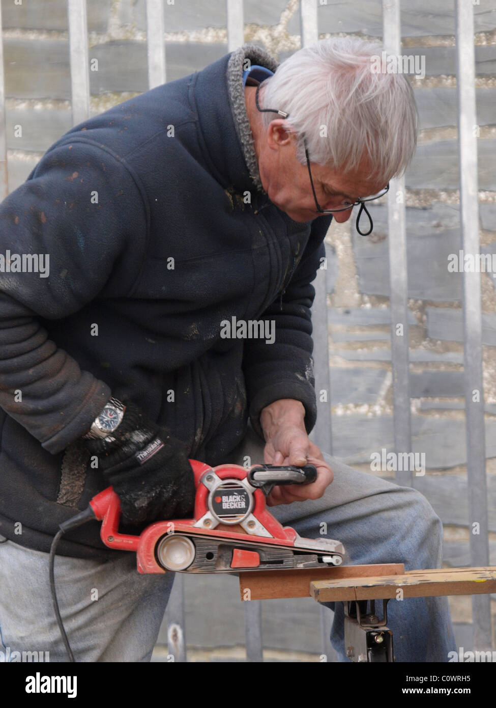 Workman using a sander, UK Stock Photo - Alamy