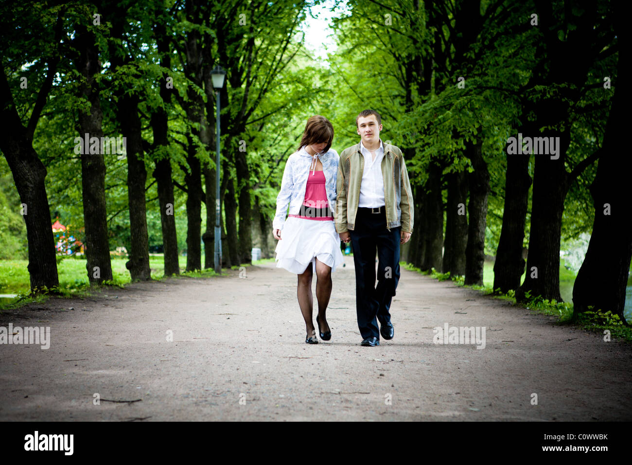 Couple walking through park holding hi-res stock photography and images ...