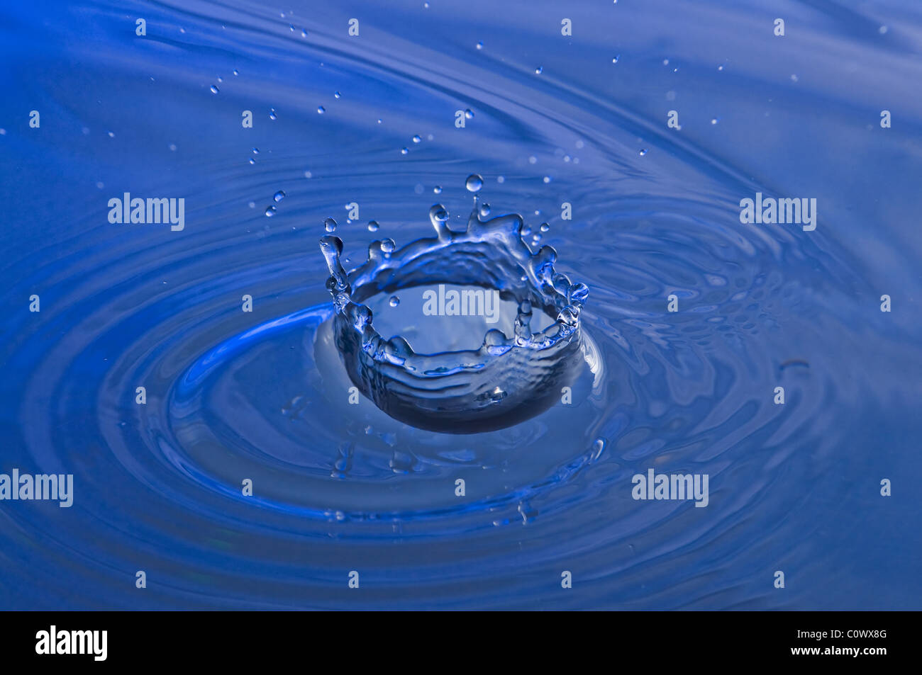 Droplet splashing into a pool of water Stock Photo - Alamy
