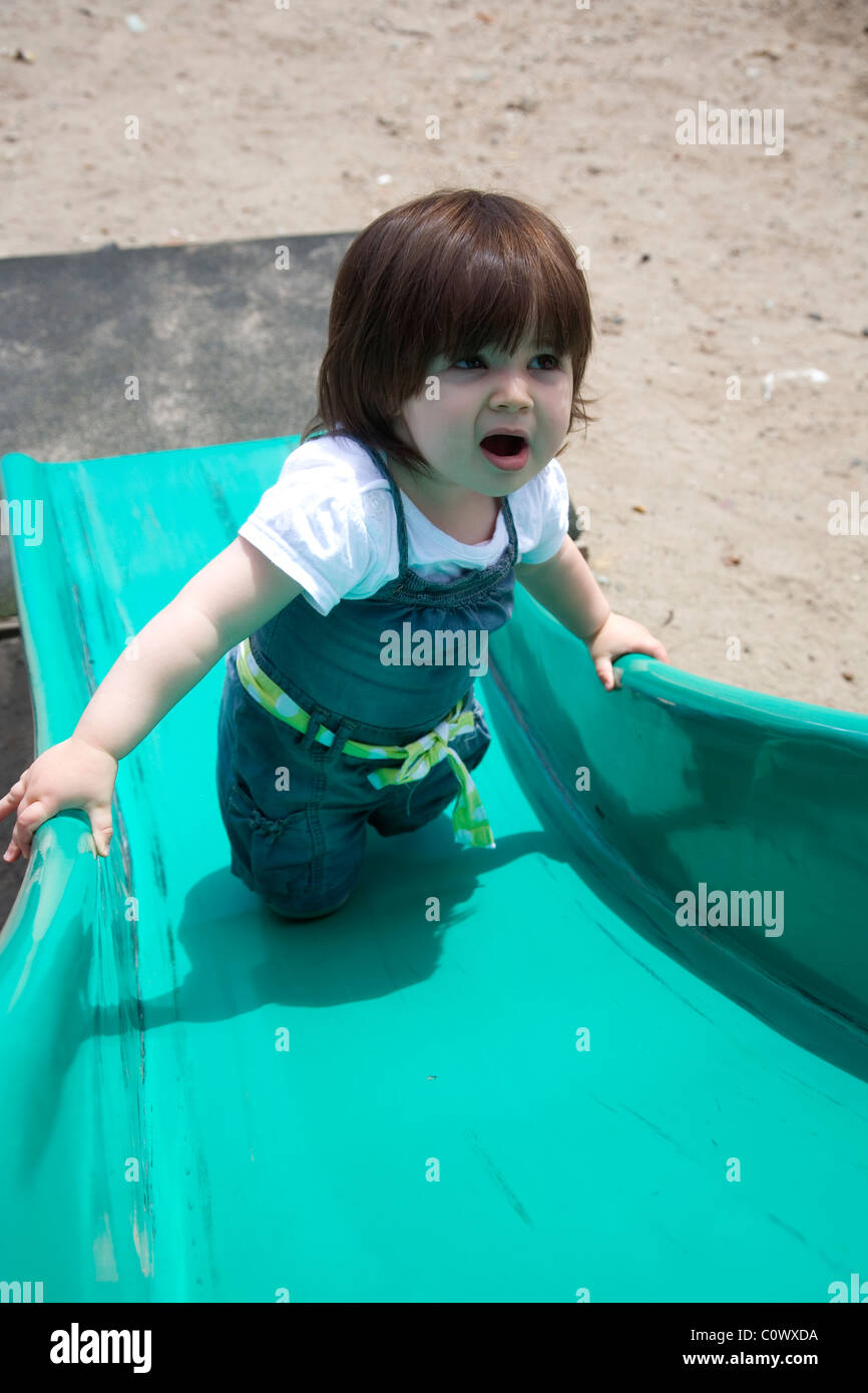 Young child climbing slide in playground Stock Photo - Alamy