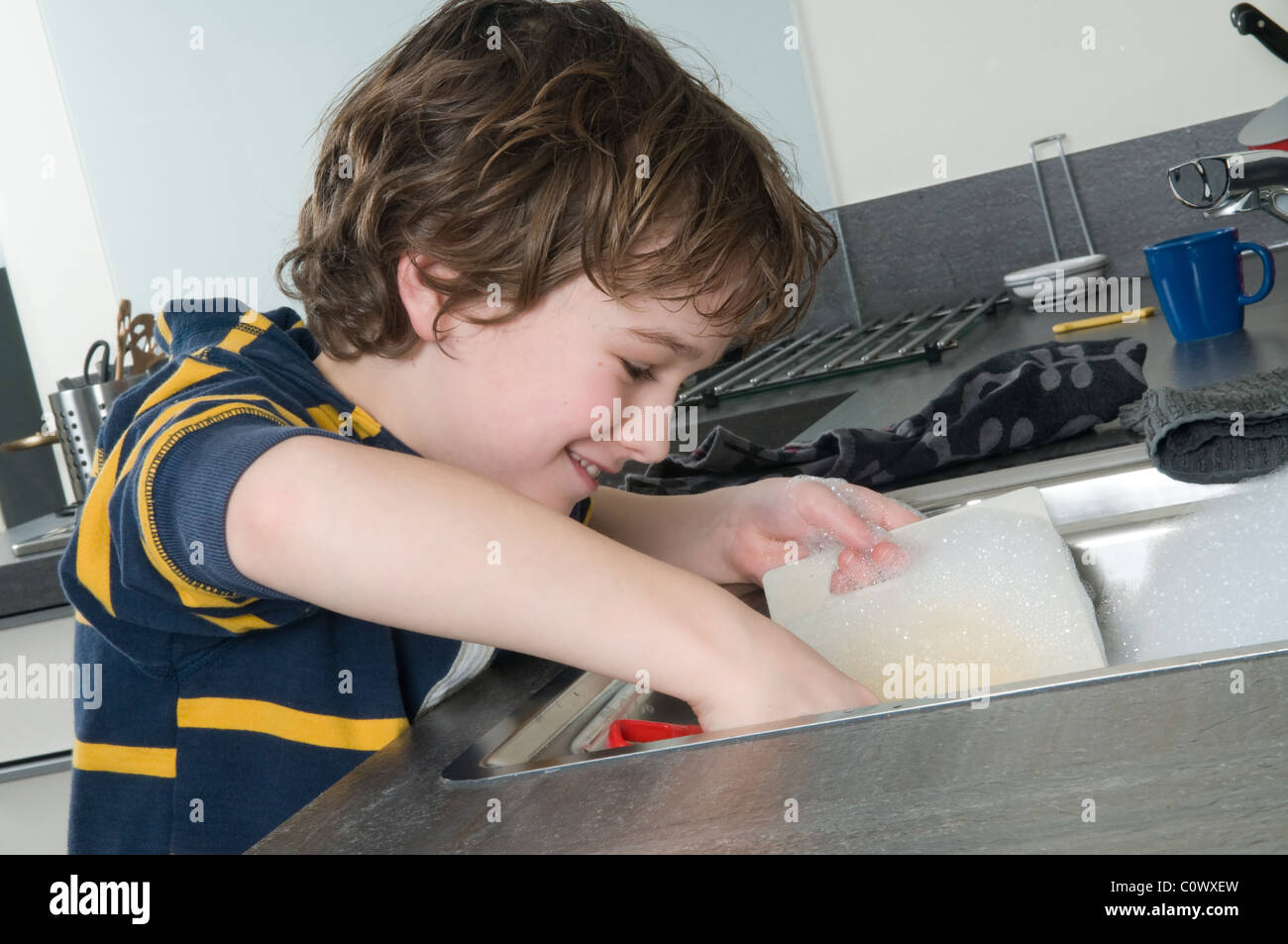 Boy doing the dishes in a modern kitchen Stock Photo - Alamy