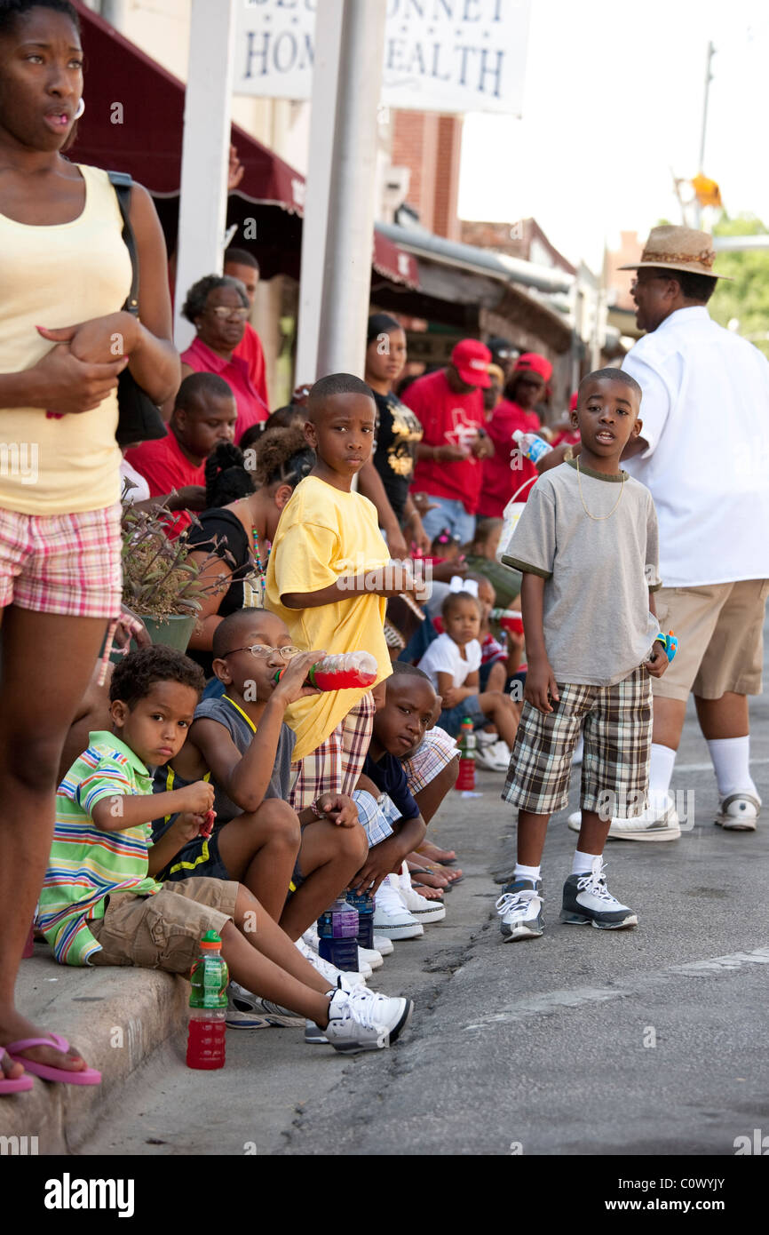African-American children wait for floats to pass by during parade ...