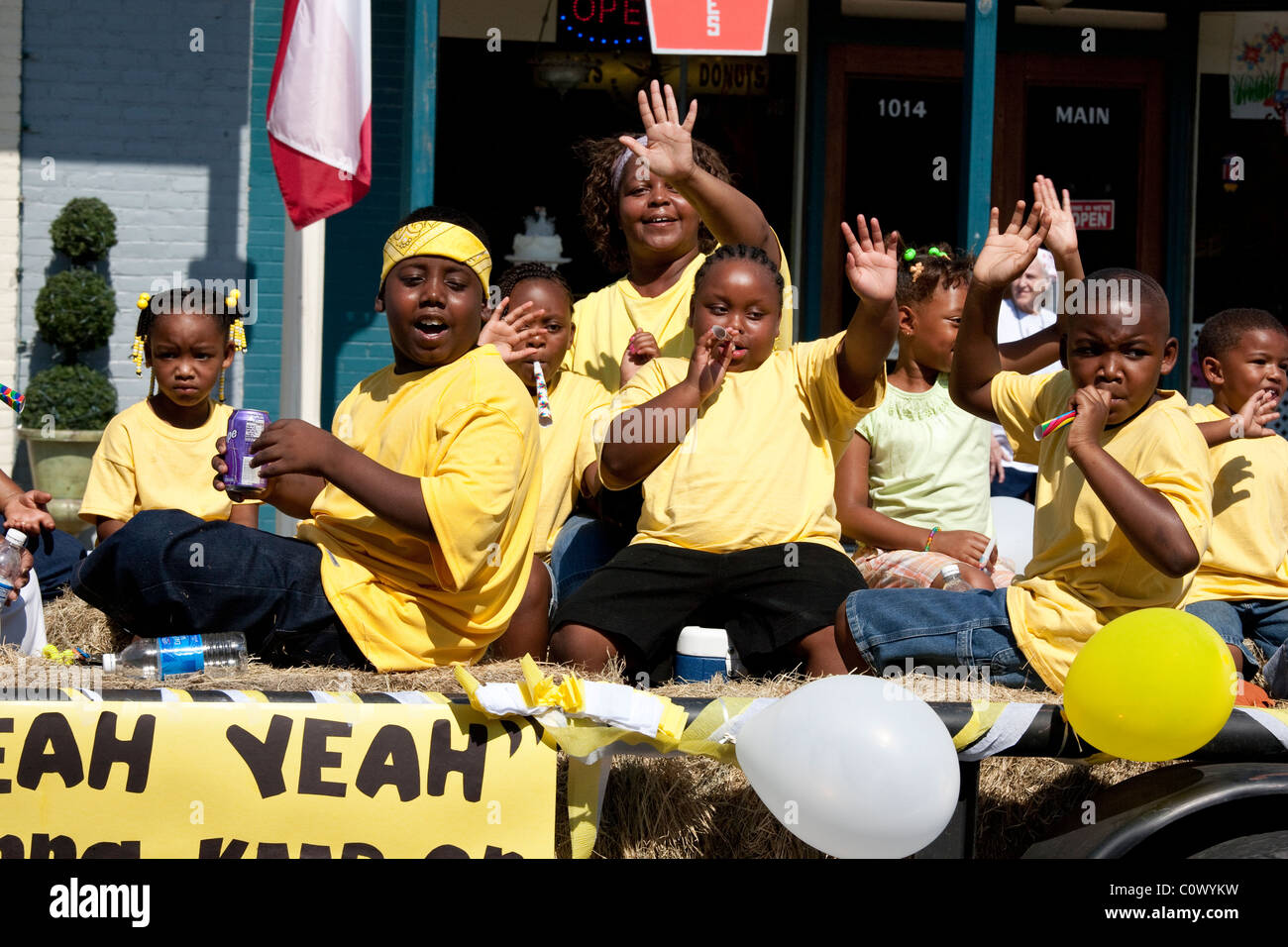 African-American children wave to spectators during a parade ...