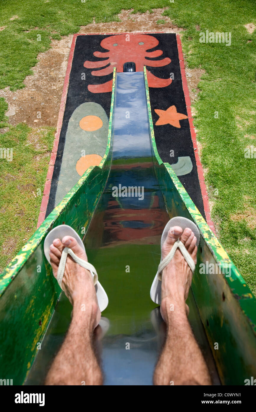 Man legs on slide - looking down Stock Photo - Alamy