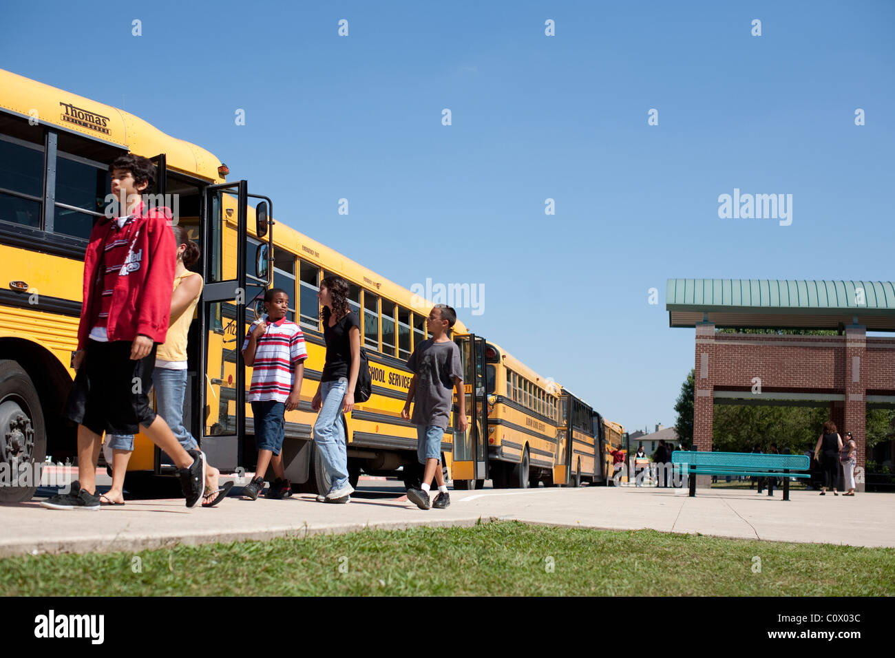Students walk to their yellow school buses at the end of the school day ...