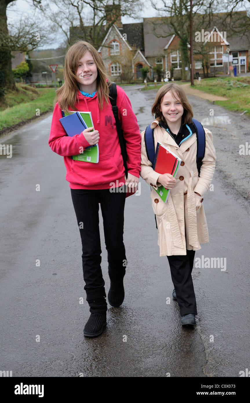 Schoolchildren walking from school along a country lane England UK ...
