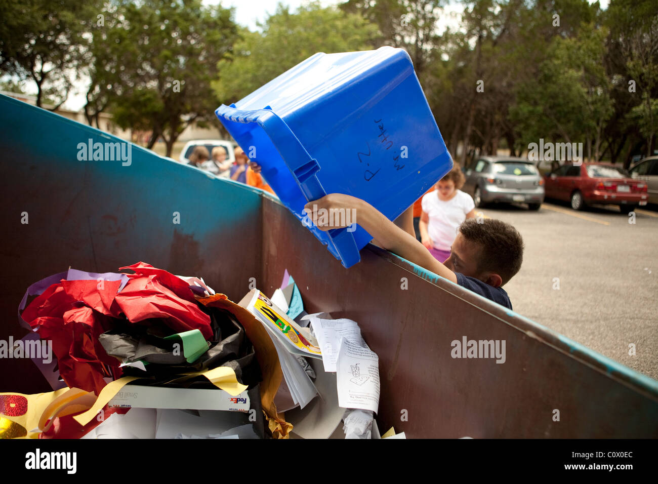 Fifth-grade elementary students carry papers to recycle dumpster at ...