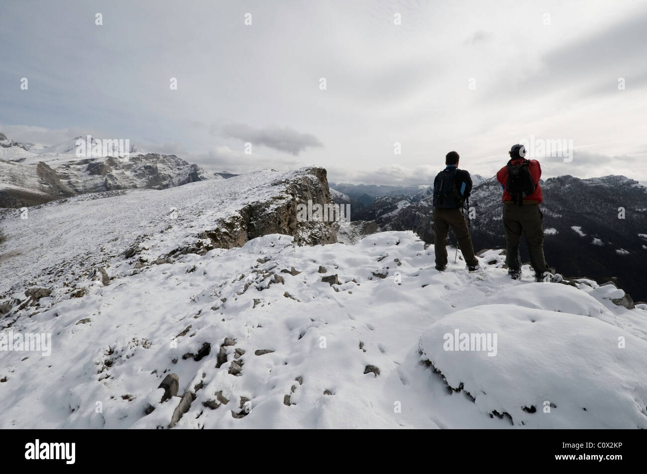 Two hikers walk through the covered in snow mountains of Ponga ...