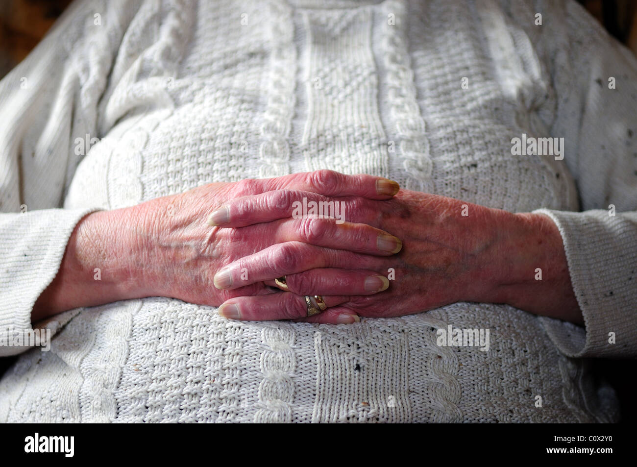 An Elderly Women at Home With Hands Clasped Stock Photo - Alamy
