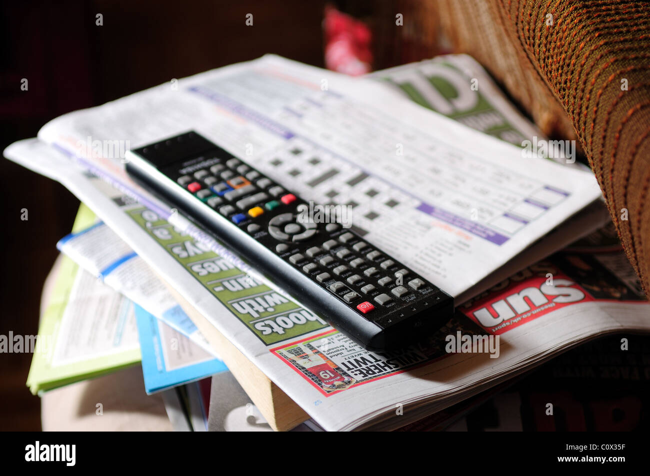 TV Remote Control with Newspaper and Magazines Stock Photo - Alamy
