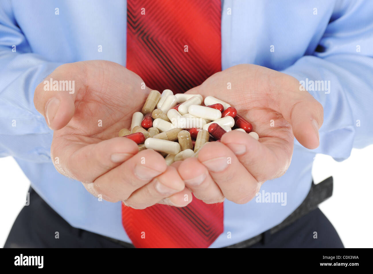 Red and white tablets in male hands Stock Photo - Alamy