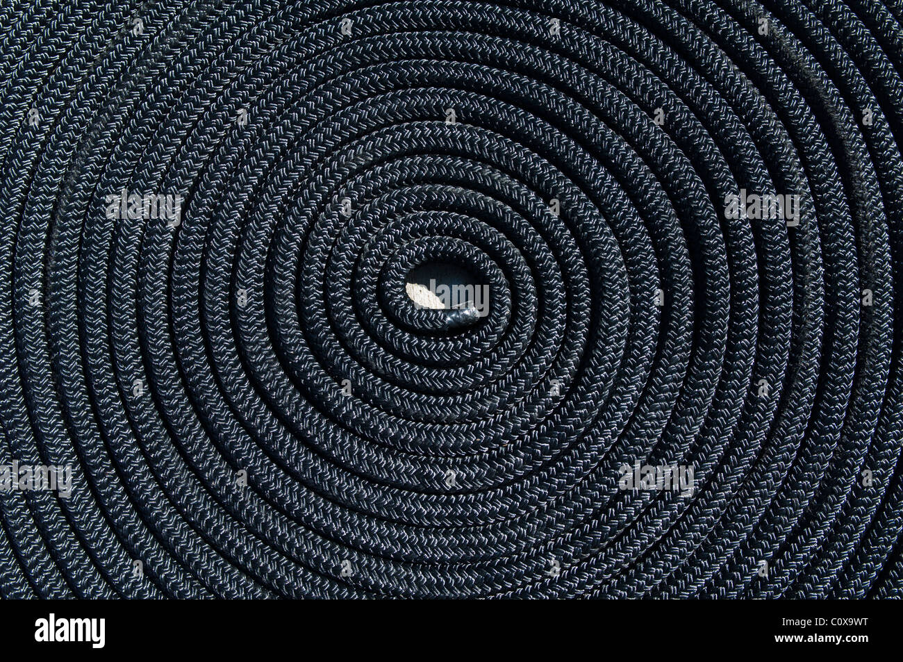 A coil of black braided mooring line Stock Photo - Alamy
