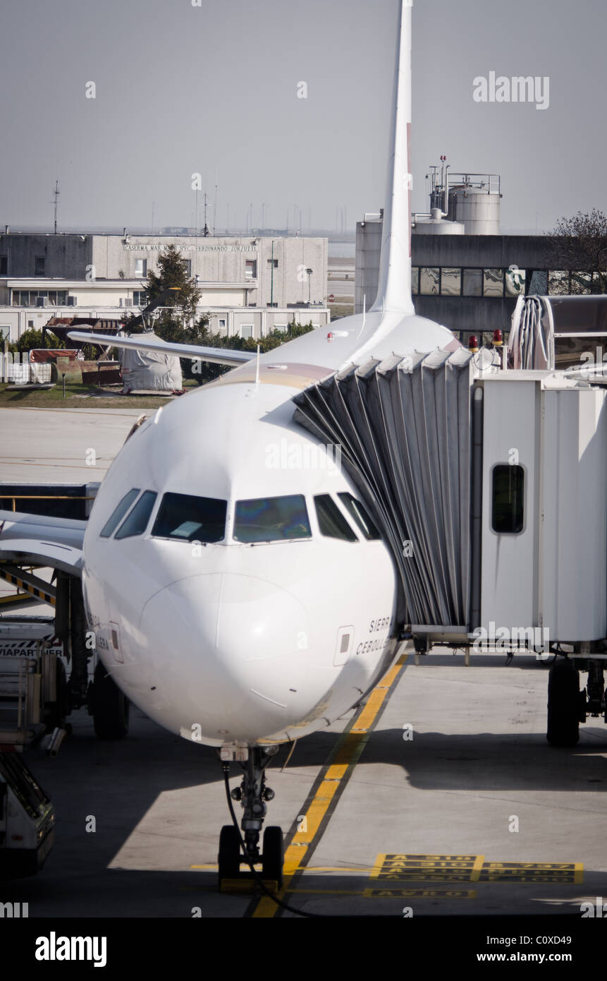 Plane docked to gangway at airport Stock Photo - Alamy