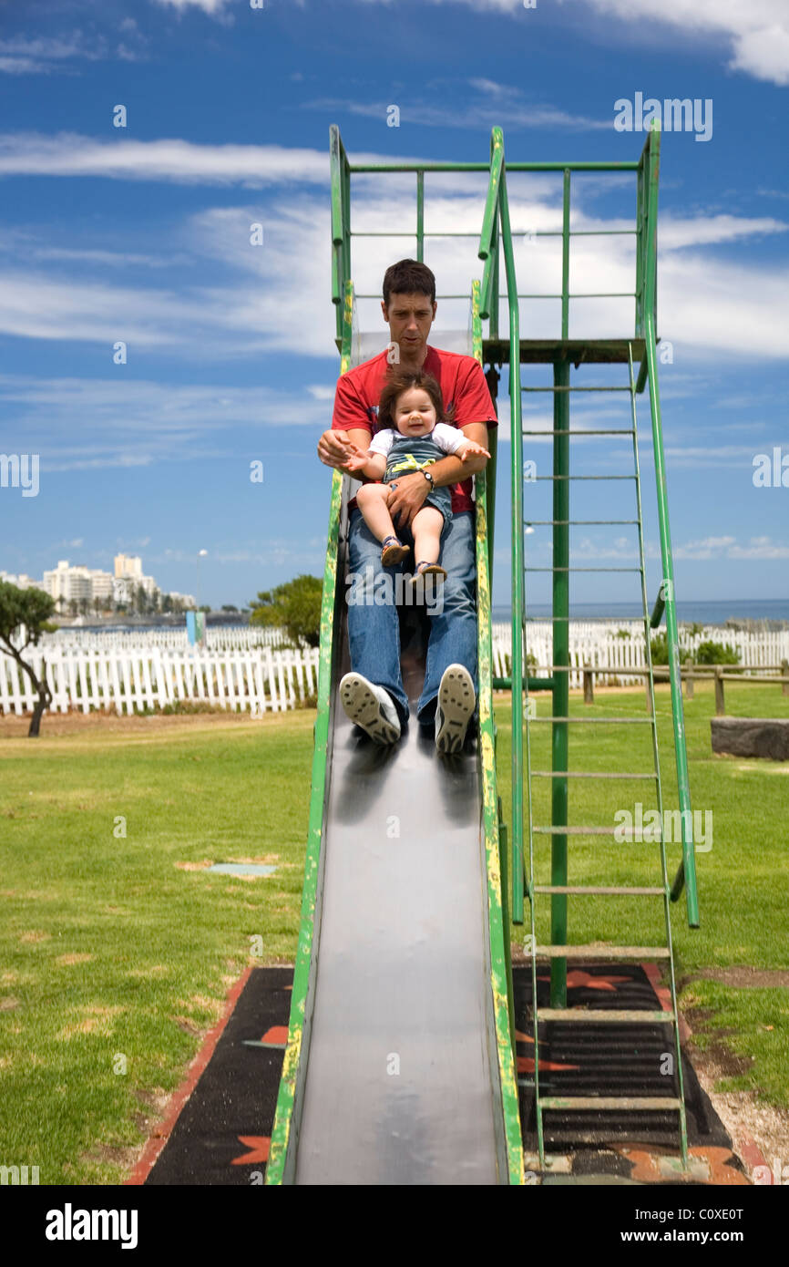 Father and Daughter going down slide at playground Stock Photo - Alamy