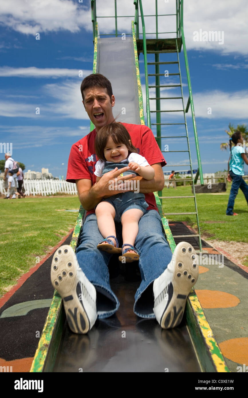 Father and Daughter going down slide at playground Stock Photo - Alamy