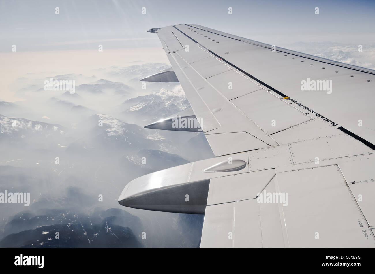 airplane wing flying over snow capped mountains Stock Photo - Alamy