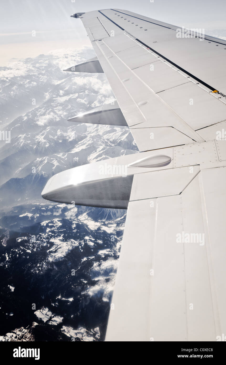airplane wing flying over snow capped mountains Stock Photo - Alamy