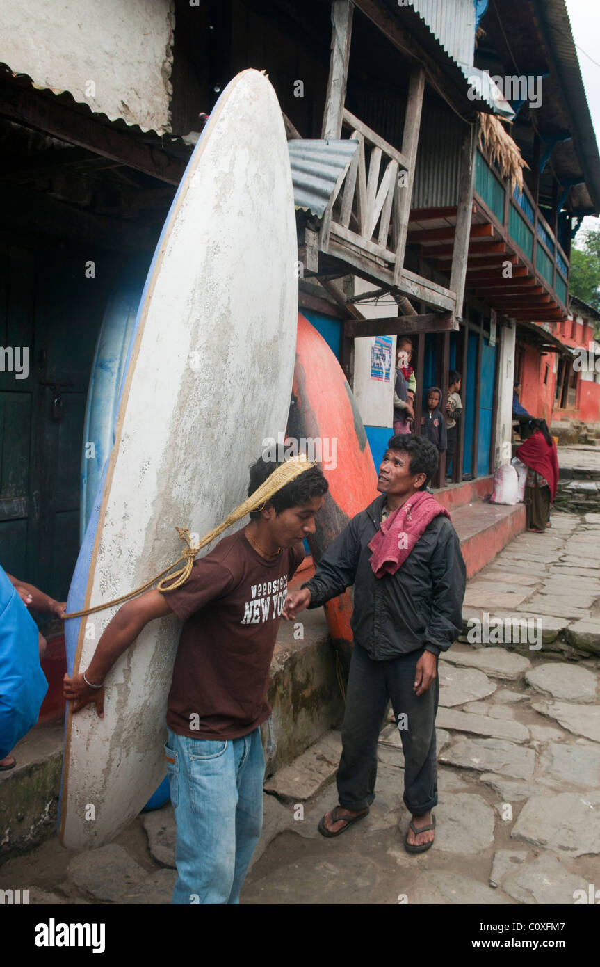 porters carrying kayaks in the village of Bulbule along the Marsyangi ...