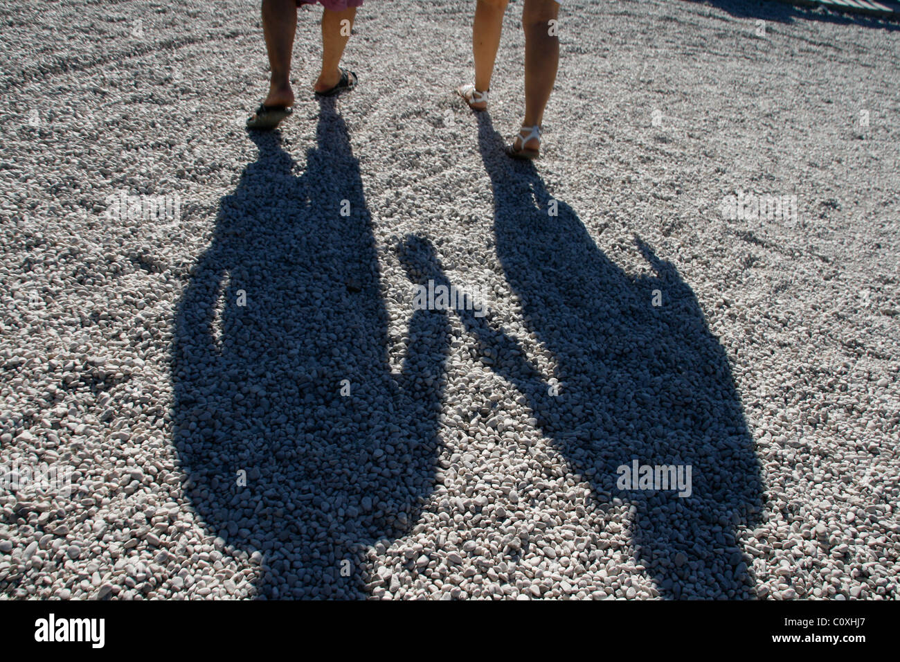 young couple holding hands shadow walking in park Stock Photo - Alamy