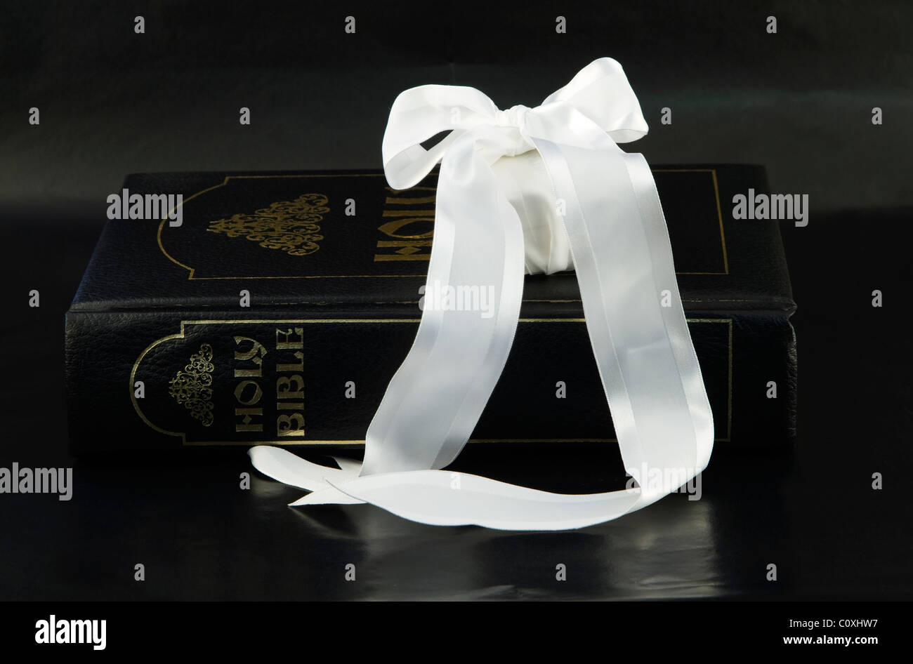 Large family Bible with white gift wrapped in white satin ribbon on ...
