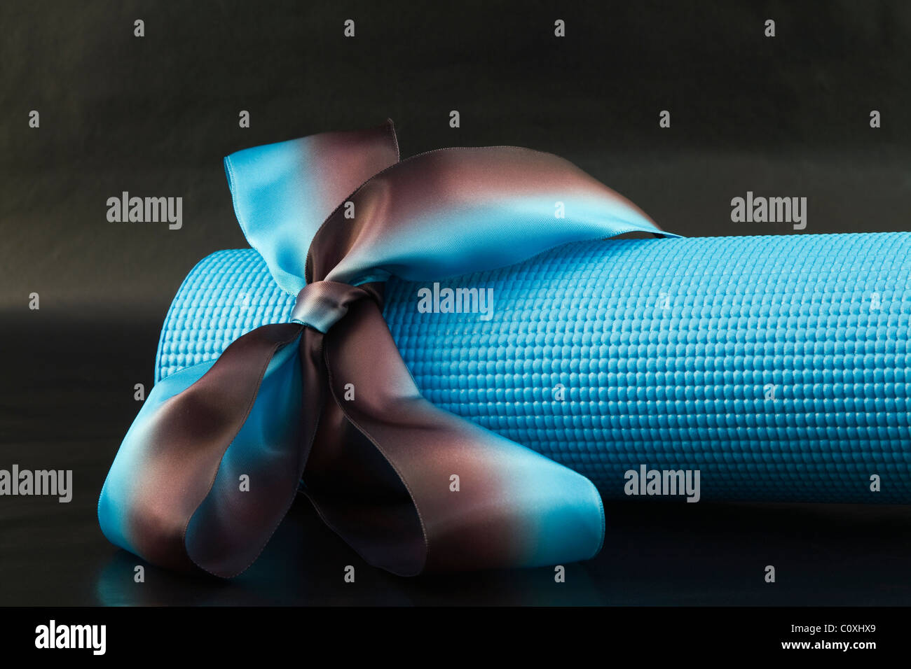 Blue yoga with a blue and brown ribbon on a black background is a ...