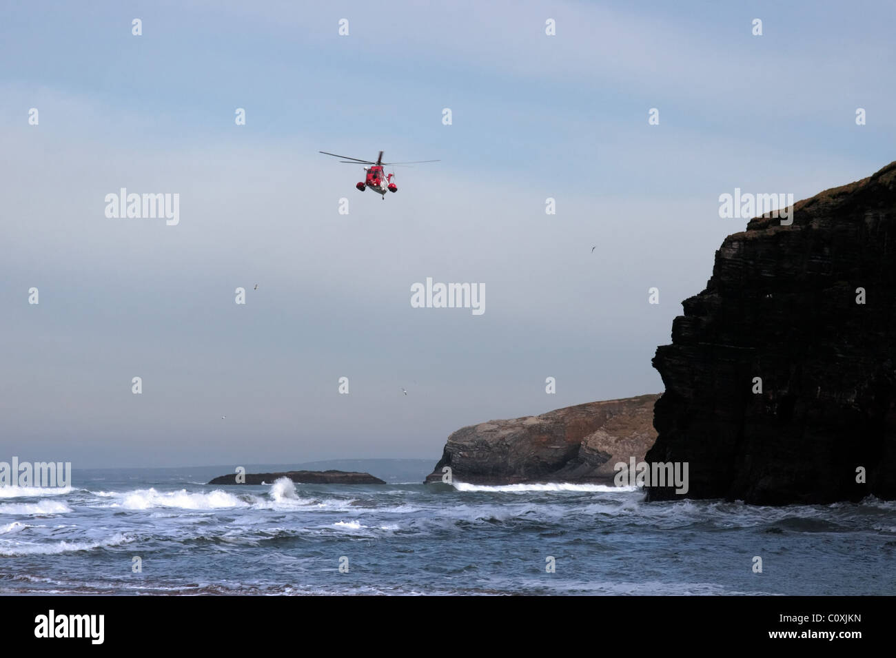 a sea rescue helicopter searching for person near to the cliffs on ...