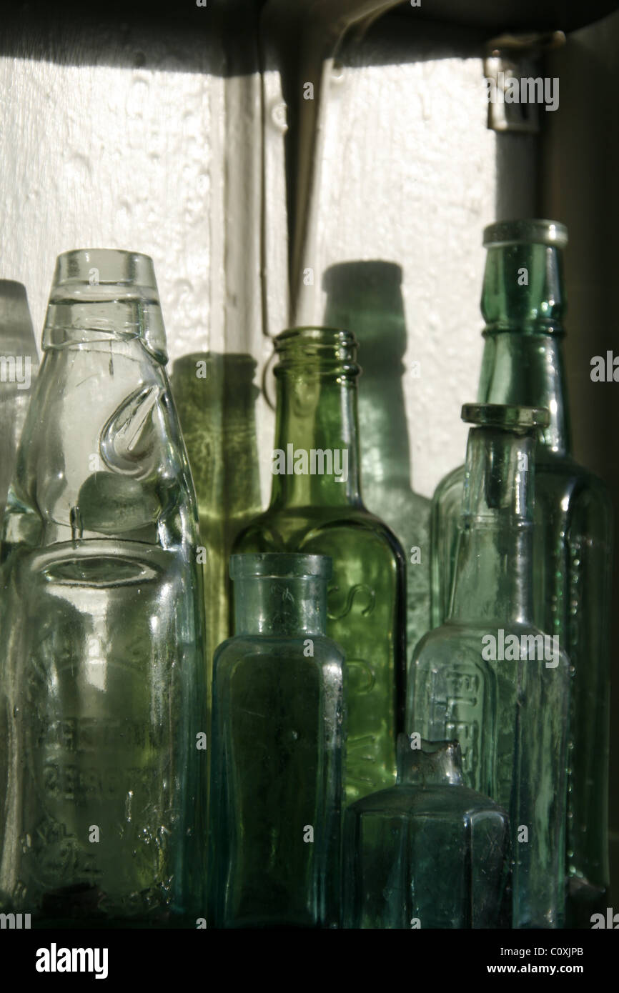 old bottles collection on house window sill Stock Photo - Alamy