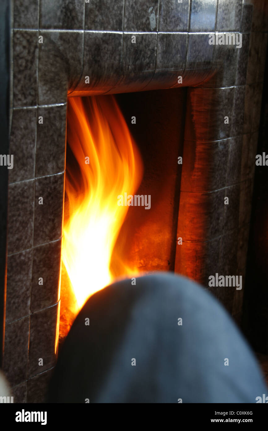 person sitting by coal fire in living room Stock Photo - Alamy