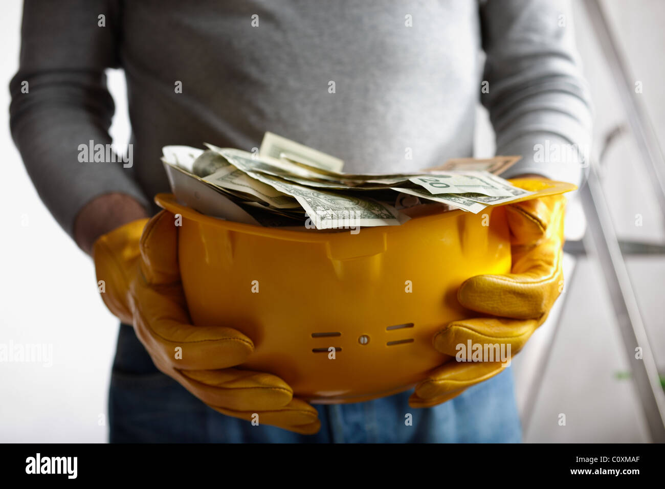 financial concept with dollars and yellow hardhat Stock Photo - Alamy
