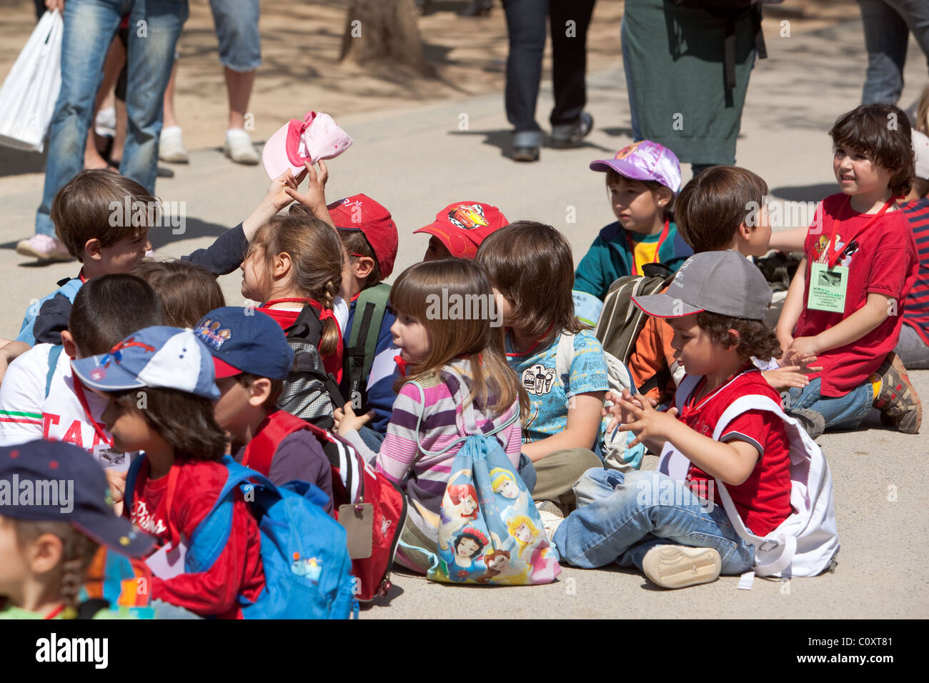Group of Children sitting on pavement during school trip. Barcelona ...