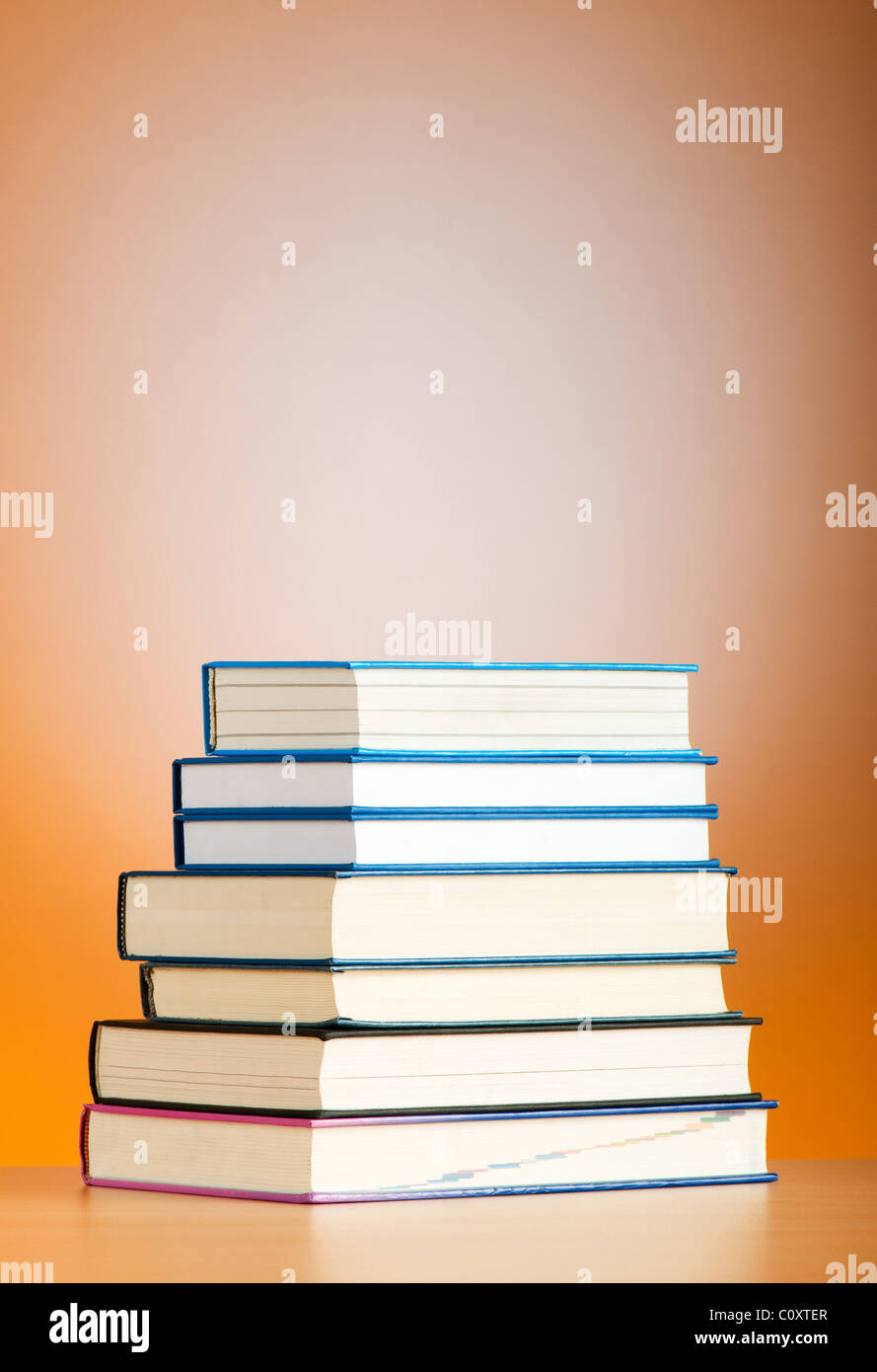Stack of text books against gradient background Stock Photo - Alamy