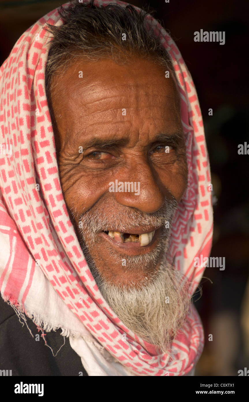 Bearded man with missing teeth wearing a head scarf at the Sonepur Mela ...