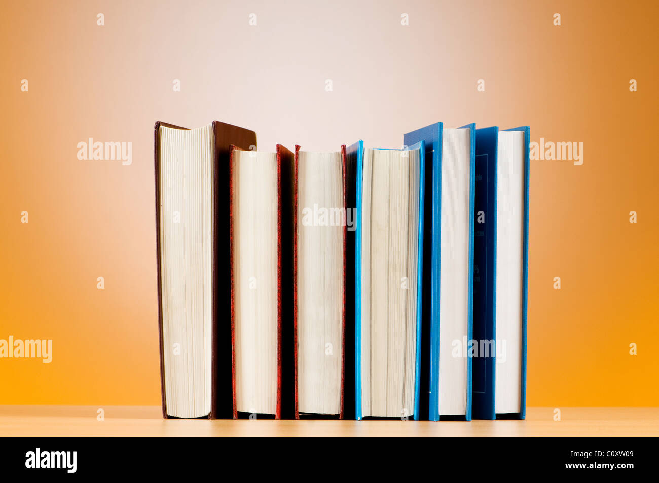 Stack of text books against gradient background Stock Photo - Alamy