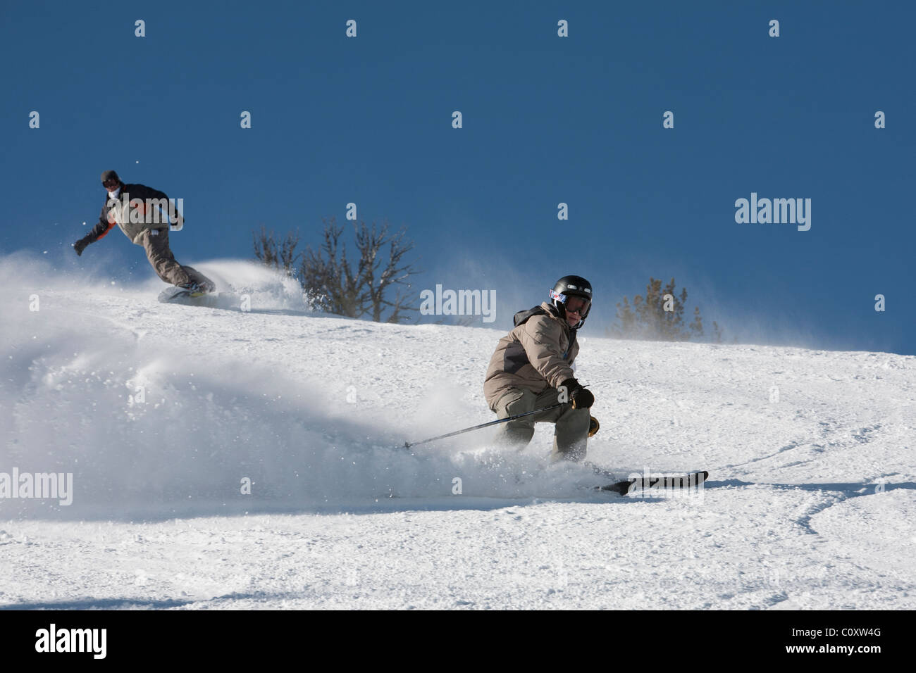 Snow flies as a snowboarder and skier descend Big Seven trail, Showdown ...
