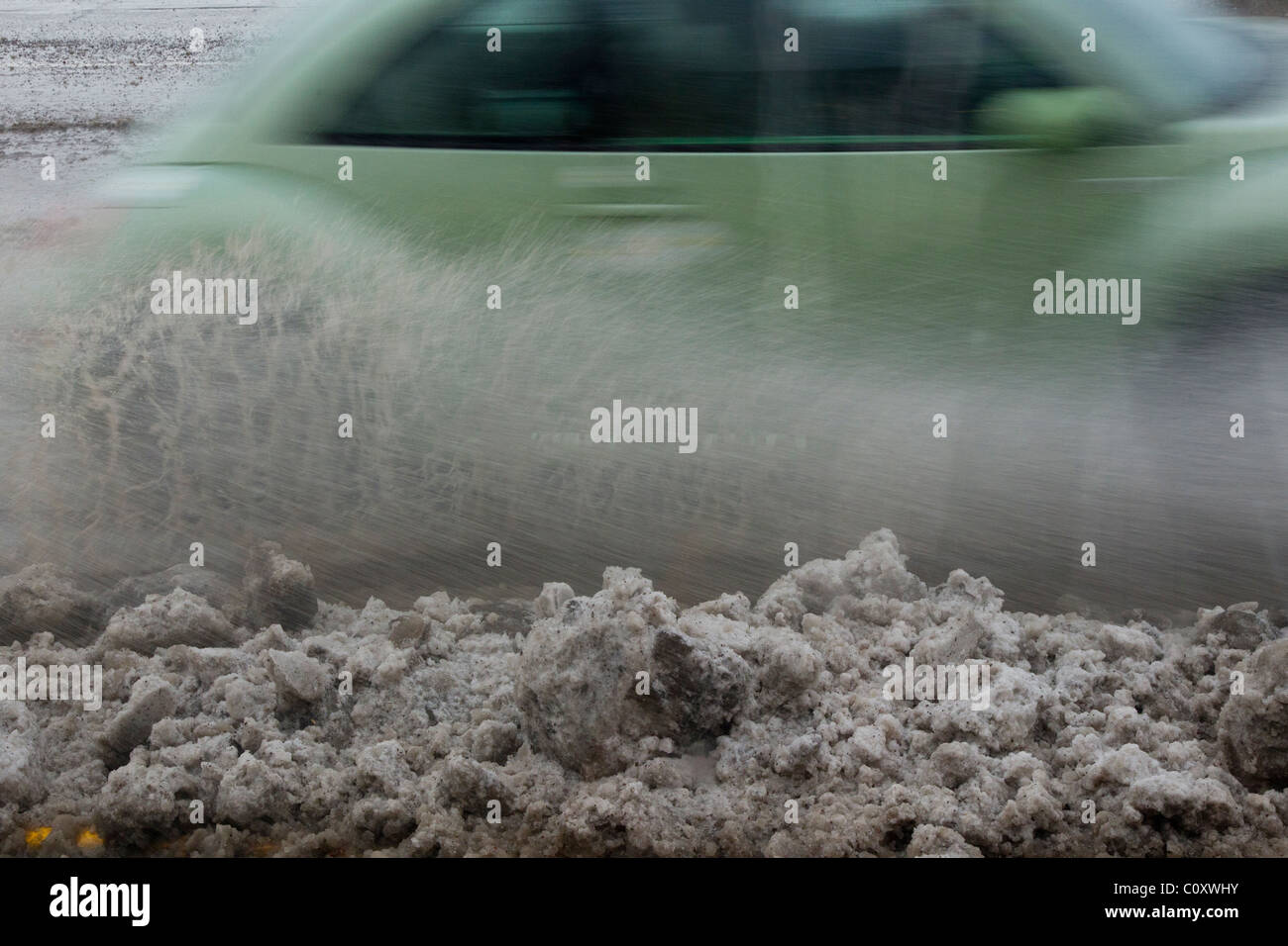 Slush flies as traffic drives on a snow and snow melt covered section ...