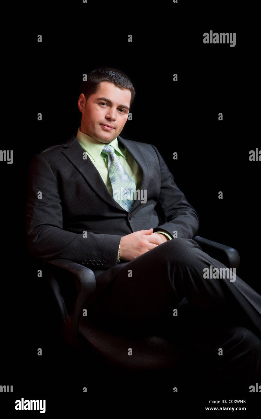 Young man wearing suit with tie sitting waiting Stock Photo - Alamy