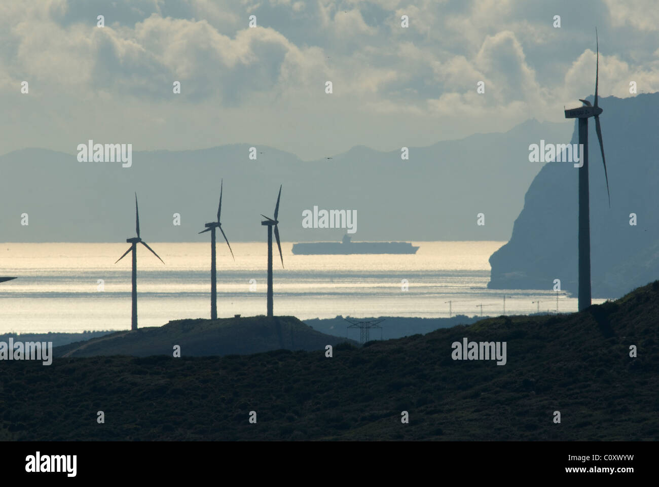 Wind turbines on Spanish mainland with container ship passing through ...