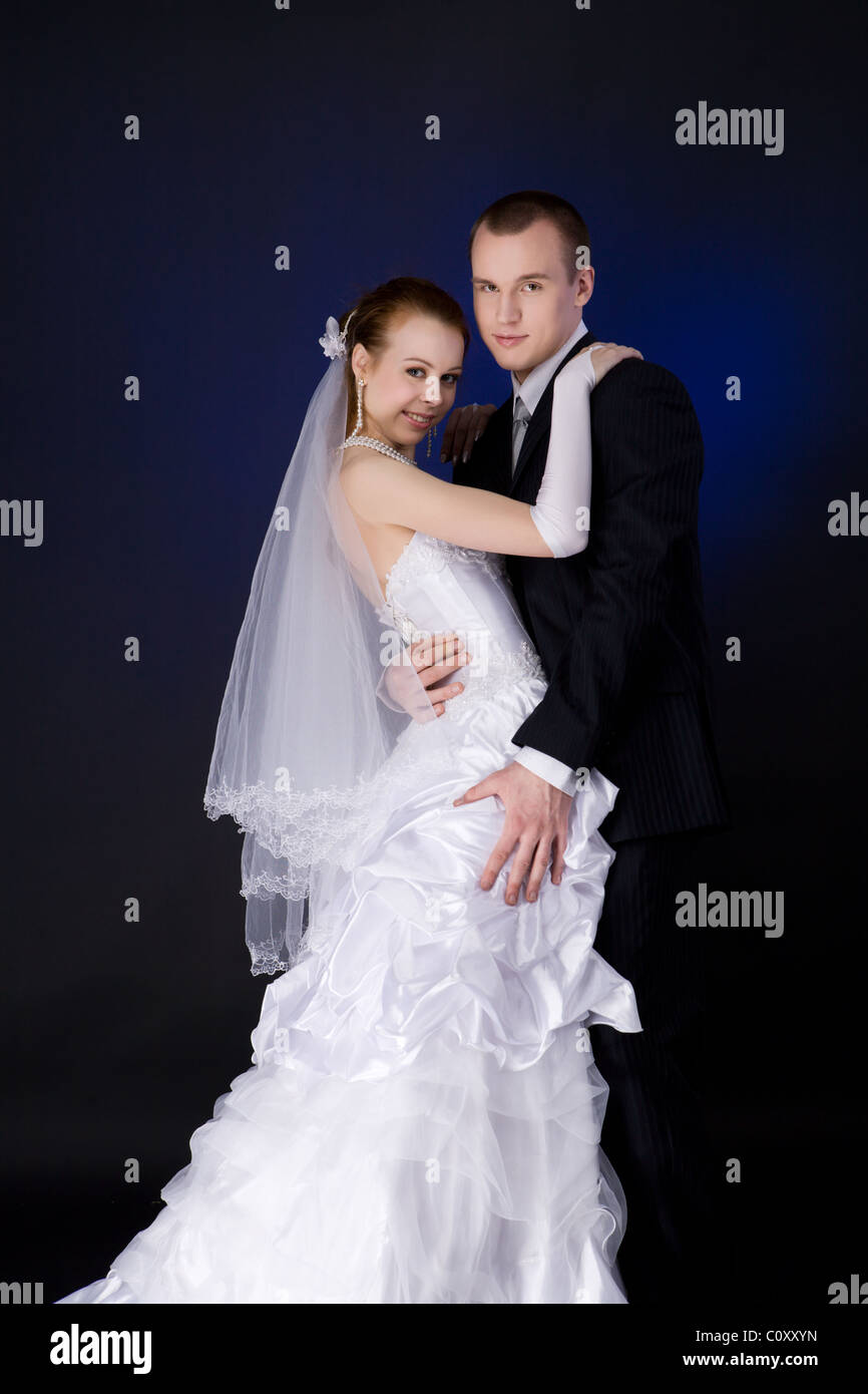 Bride and groom studio portrait over blue background Stock Photo - Alamy