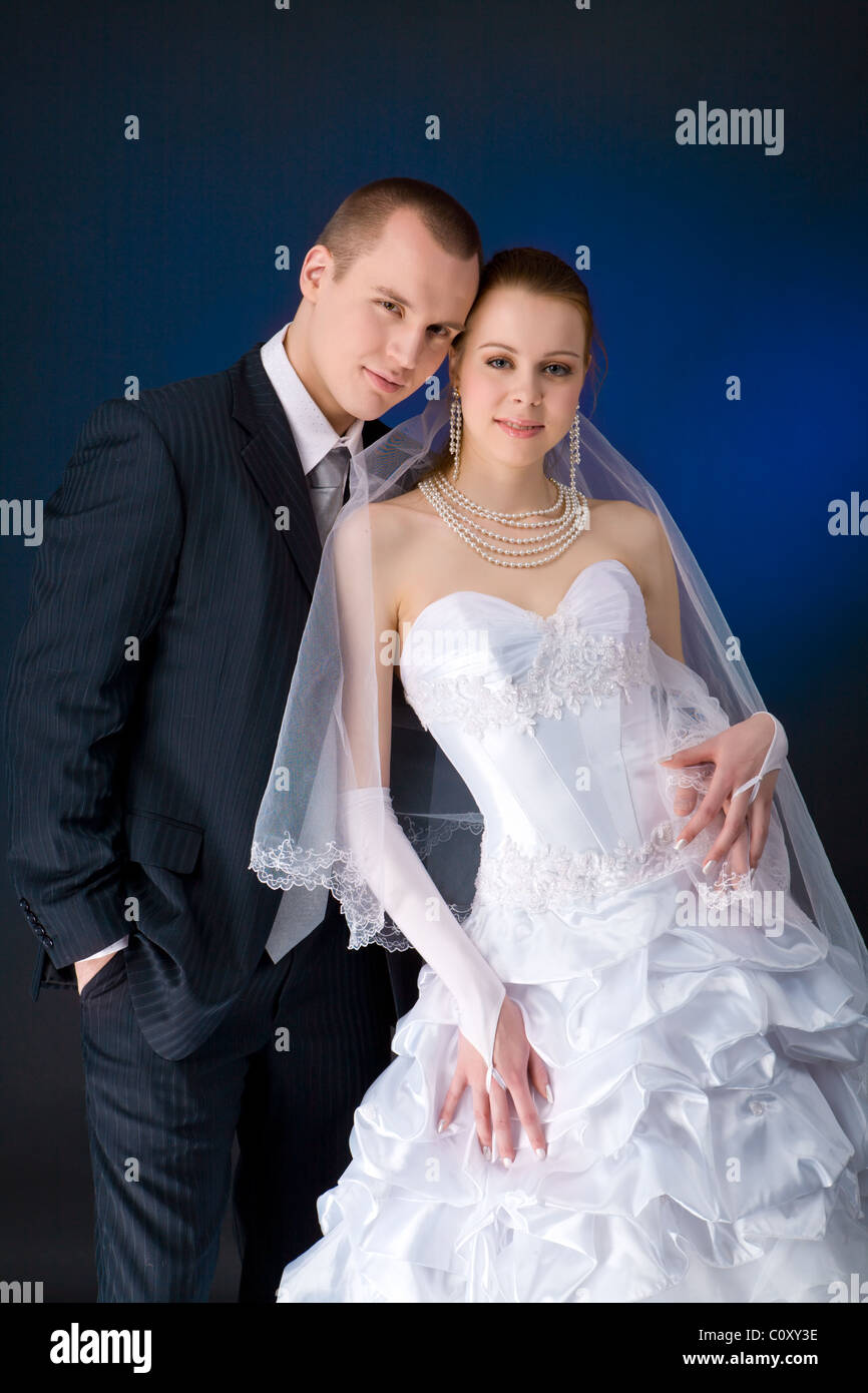 Bride and groom studio portrait over blue background Stock Photo - Alamy