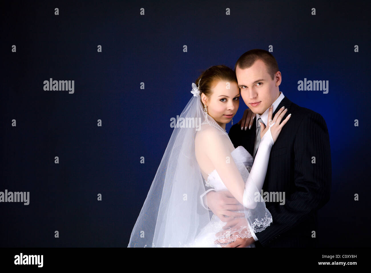 Bride and groom studio portrait over blue background Stock Photo - Alamy