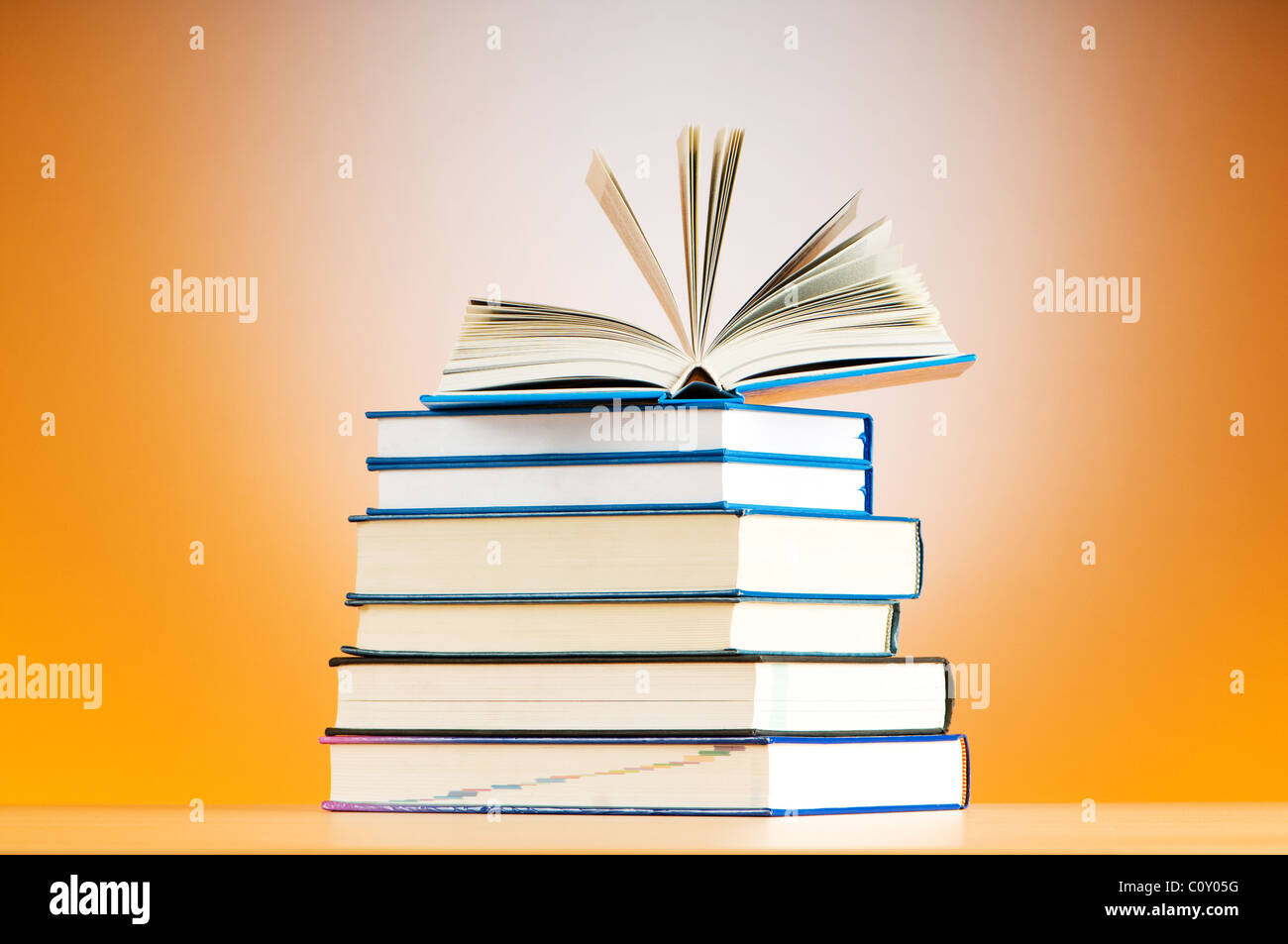 Stack of text books against gradient background Stock Photo - Alamy
