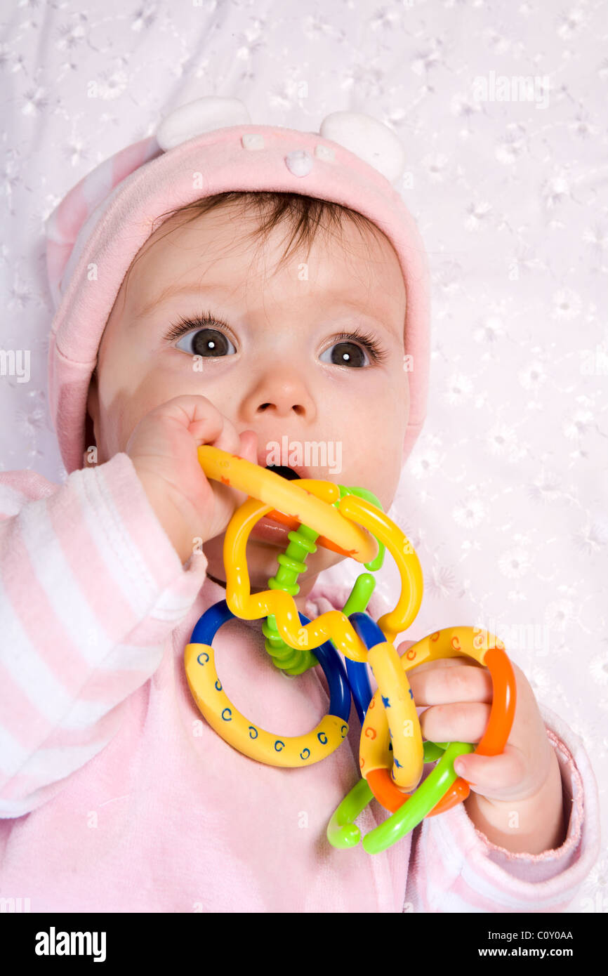 Portrait of Baby with vibrant chain toy wearing hat Stock Photo - Alamy