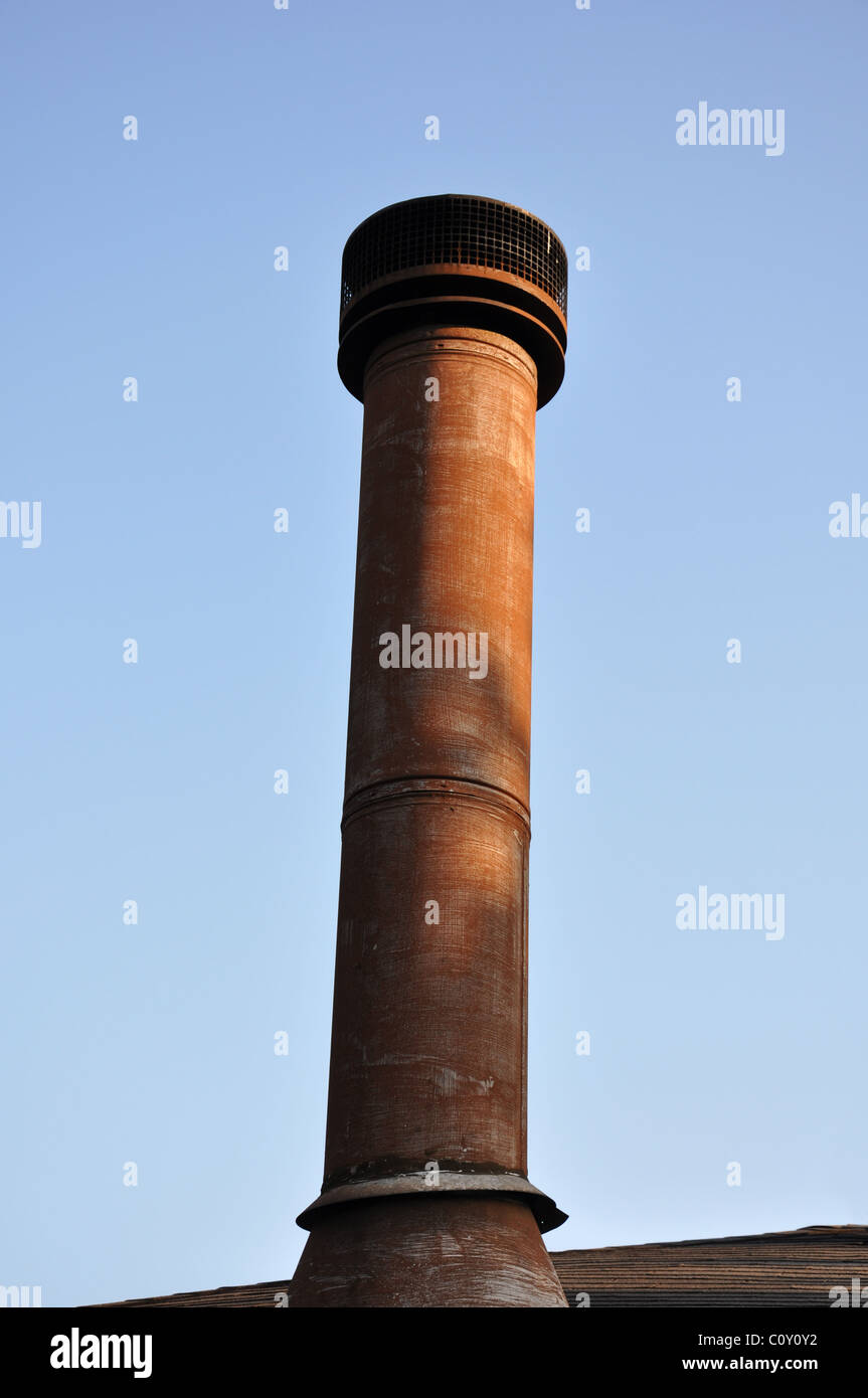 An old smoke stack against a blue sky Stock Photo - Alamy
